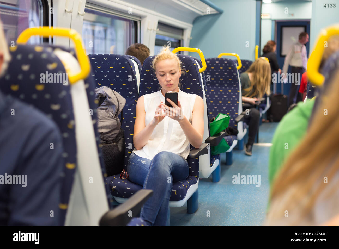 Woman sitting underground train using cell phone hi-res stock photography and images - Alamy