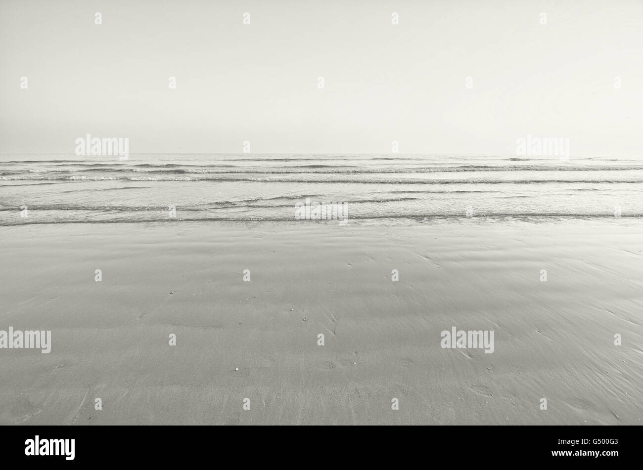 A very low solstice tide, waves barely breaking Stock Photo - Alamy