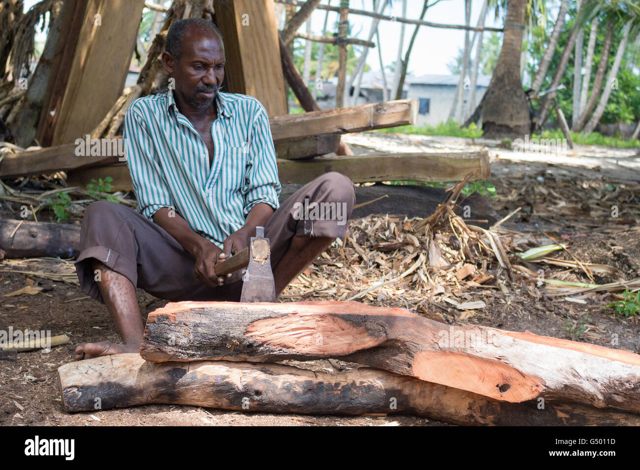 Tanzania, Zanzibar, Nungwi, man working wood with ax, Dhau-Bau Stock ...
