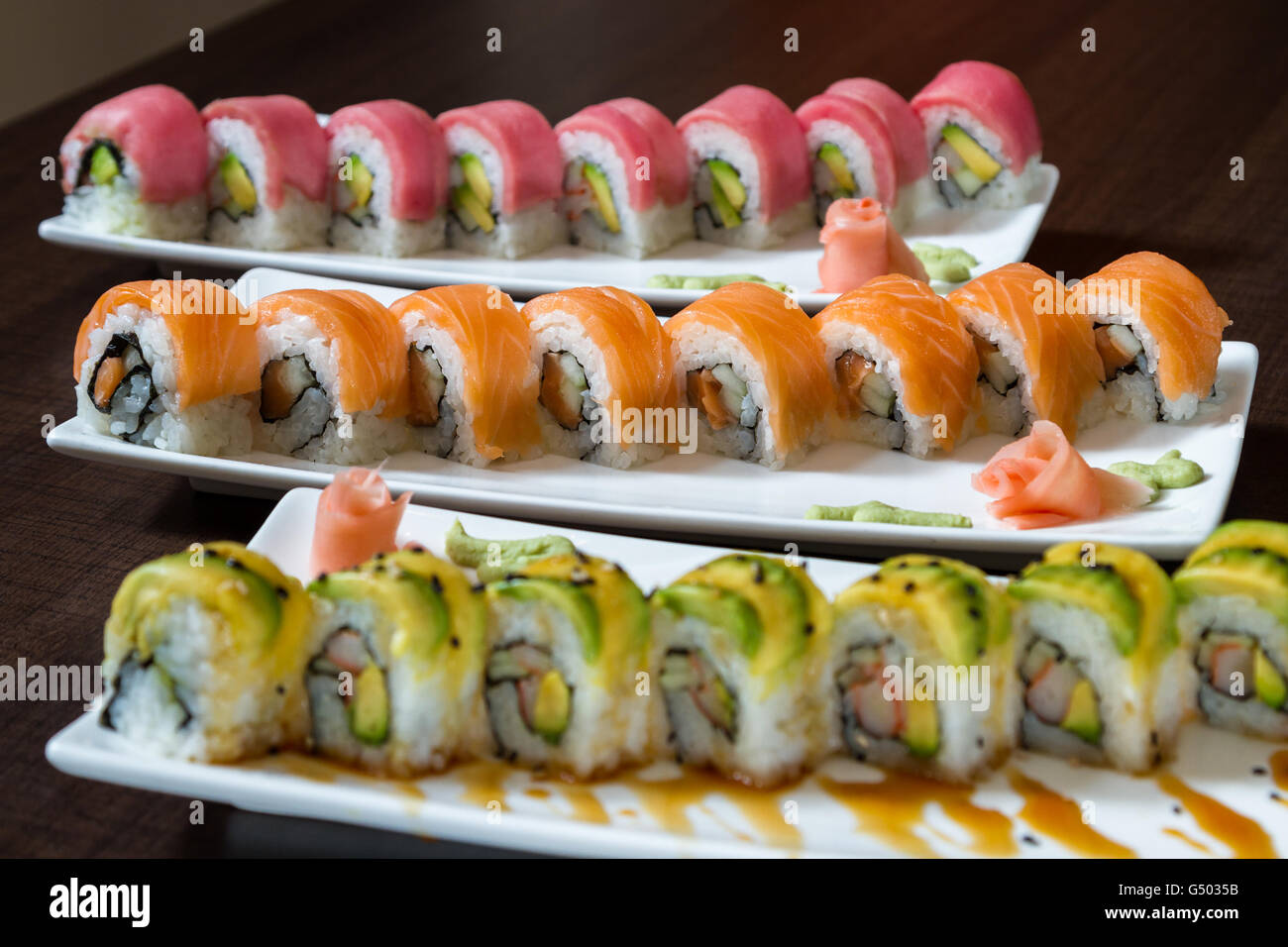close up of a variety of sushi rolls in different colors and flavors ...