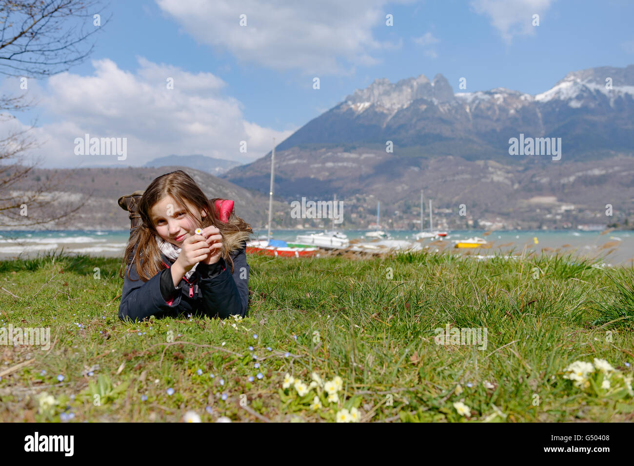 a pretty preteen is lying in the green grass, in the spring Stock Photo ...