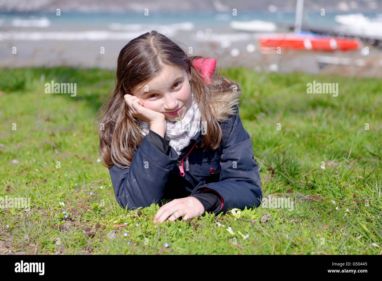 a pretty preteen is lying in the green grass, in the spring Stock Photo ...