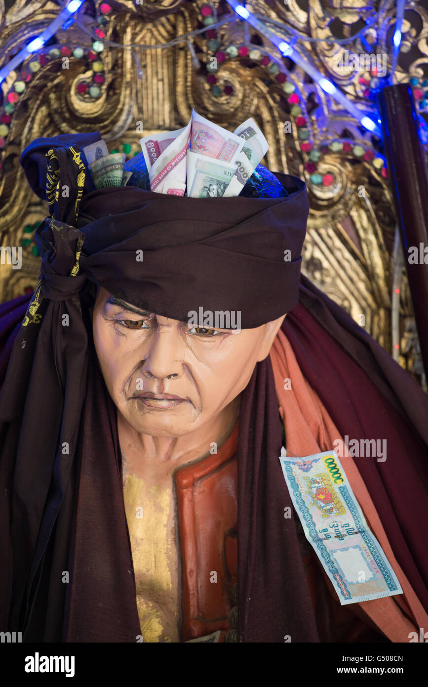 Statue of a nat spirit with banknotes offered, Mount Popa Buddhist ...