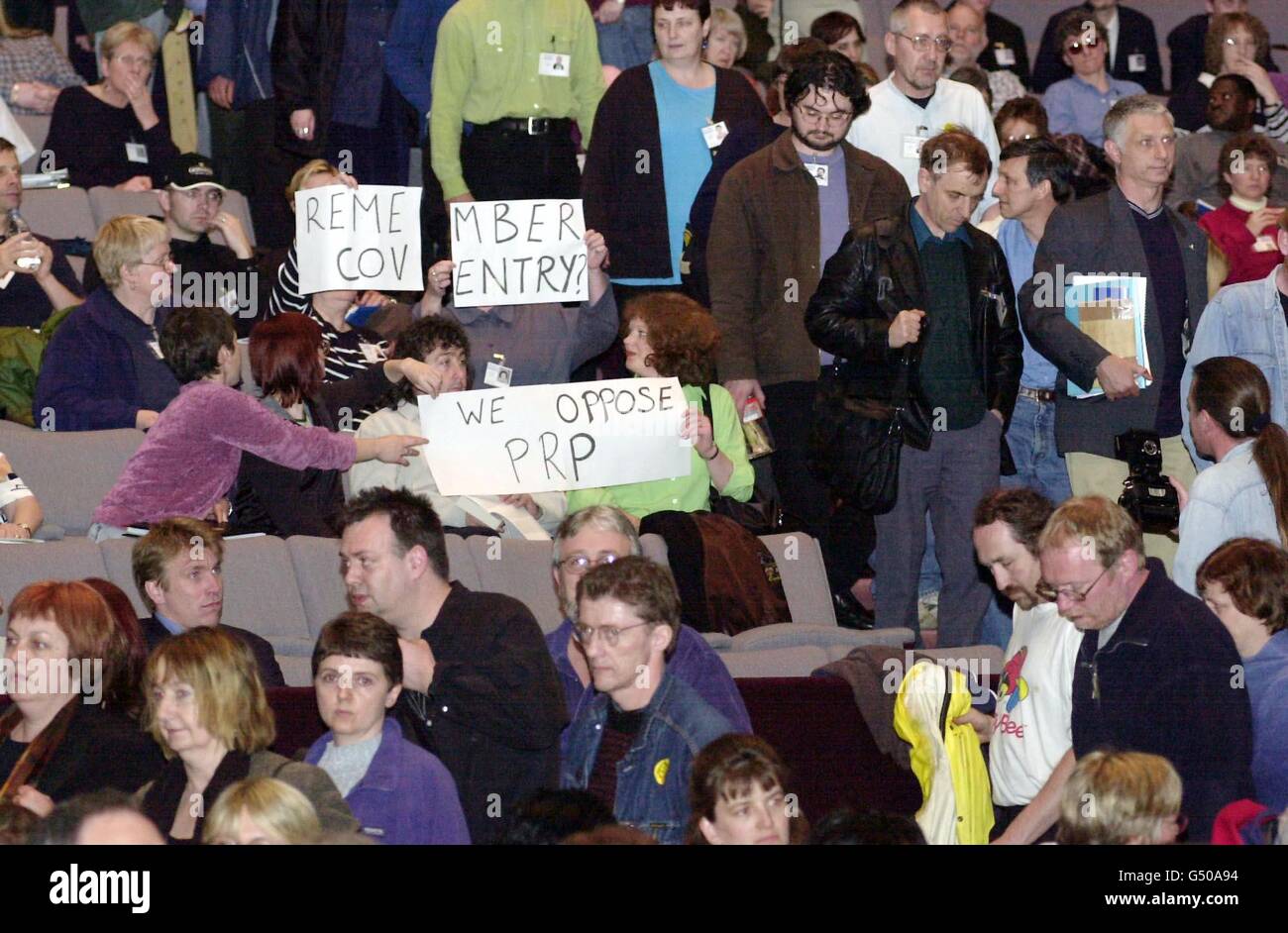 Delegates leave the conference hall, while others hold up posters ...