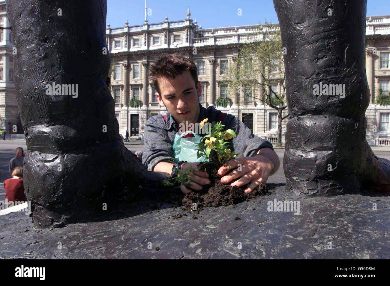 A protester plants a flower between the legs of the one of the statues ...