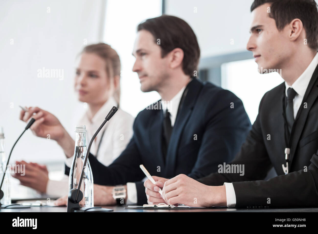 Business people speaking at presentation in microphones in office Stock ...