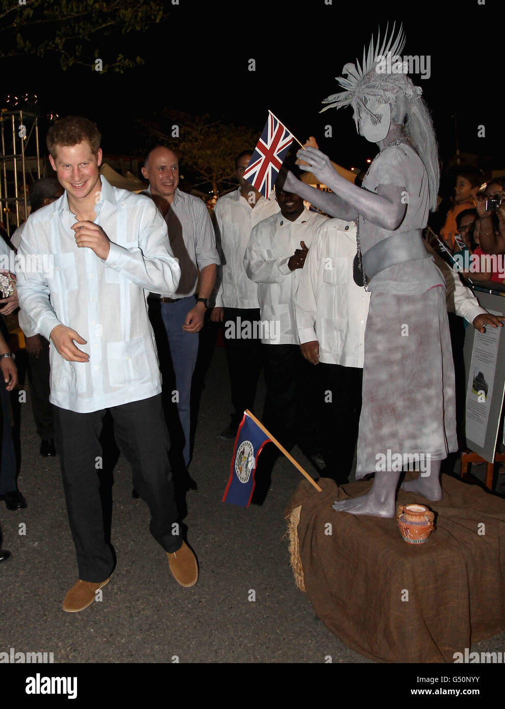 Prince Harry meets a human statue during a walkabout at a "block party ...