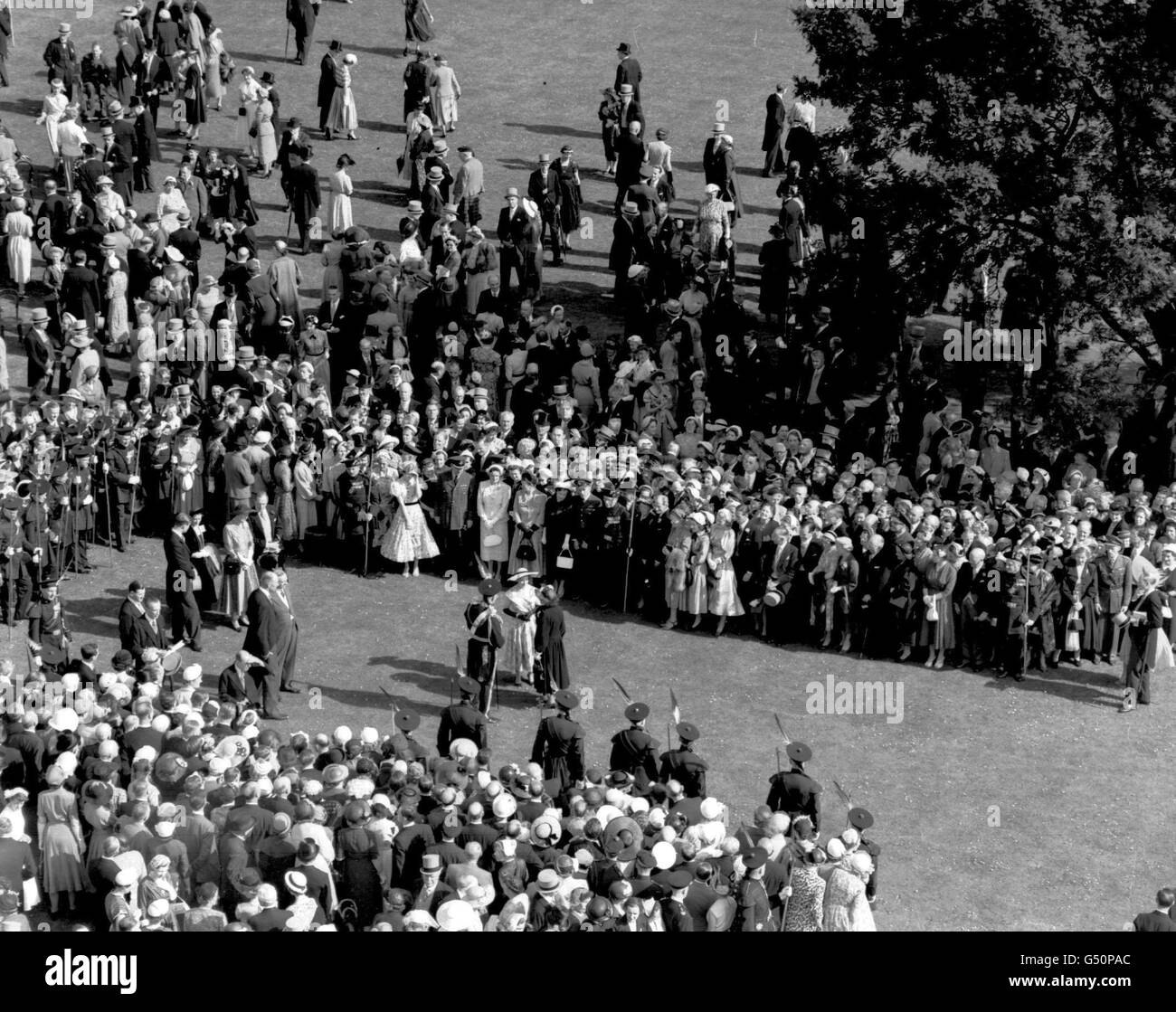 The Queen (centre of path) speaks with guests at a Garden Party she ...