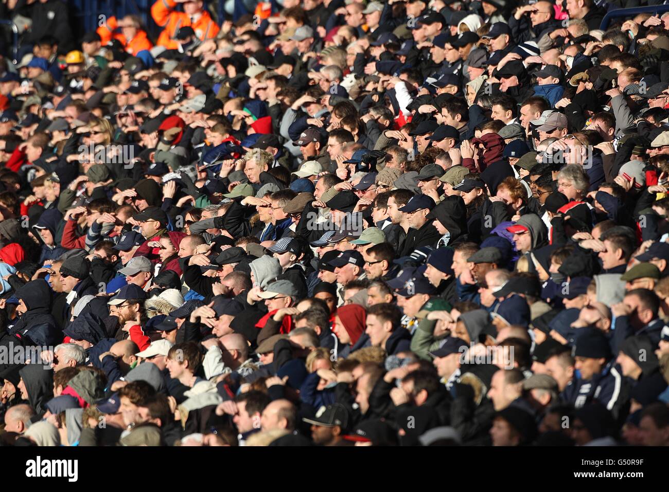 A sea of fans shield their eyes from the sun, in the stands Stock Photo ...