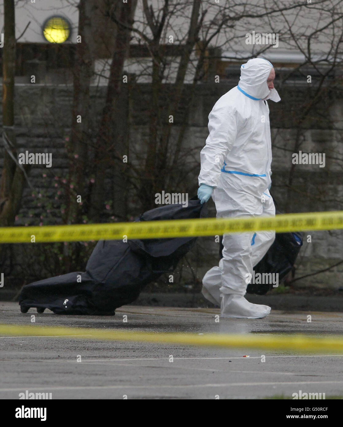 Police forensic officers gather evidence at the scene of a shooting ...