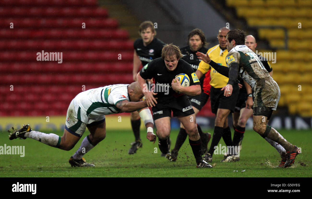 Saracens' Rhys Gill is tackled by Northampton's Soane Tonga'uiha (left ...