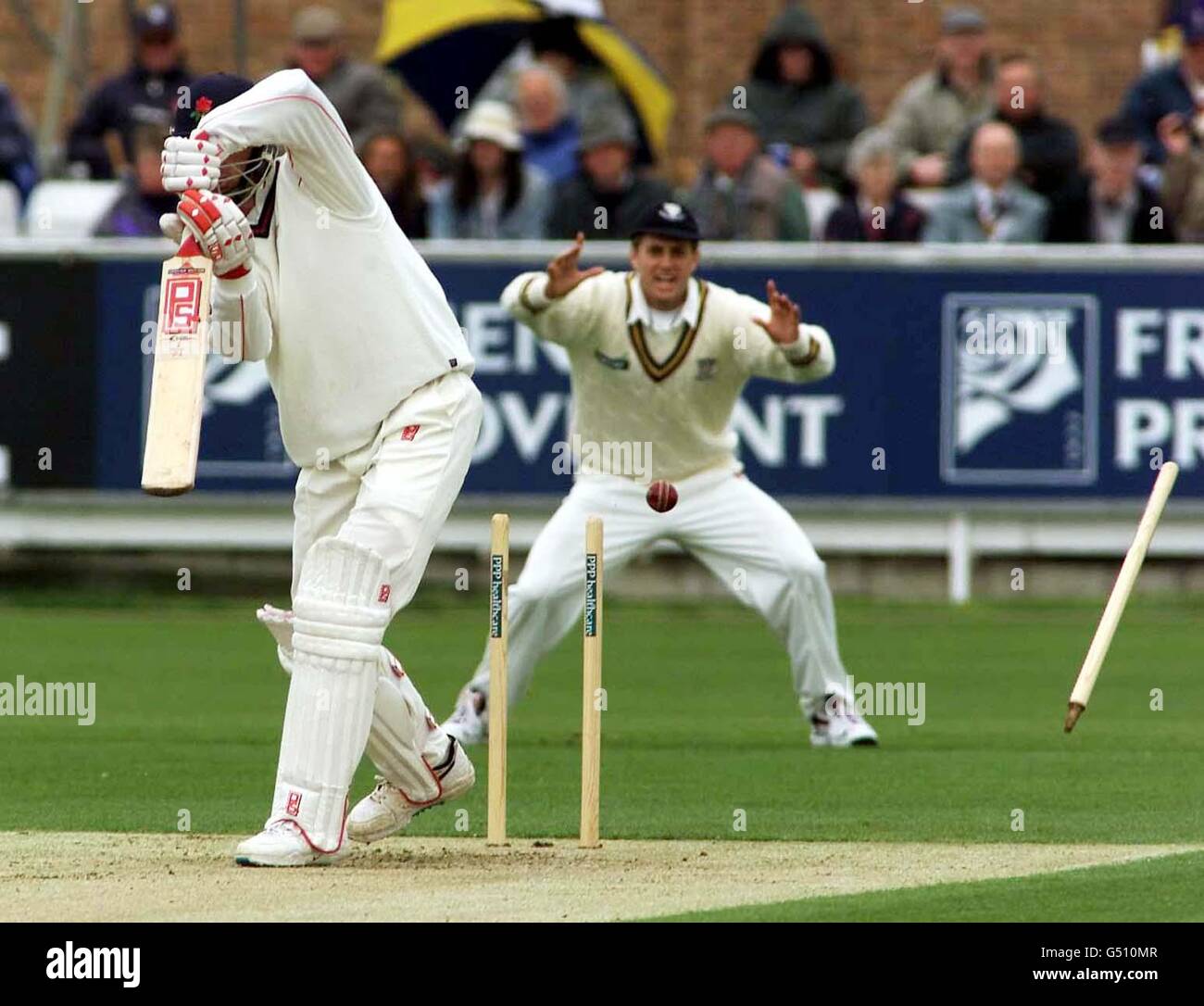 Lancashire's opening batsman John Crawley (L) is bowled by Durham's ...