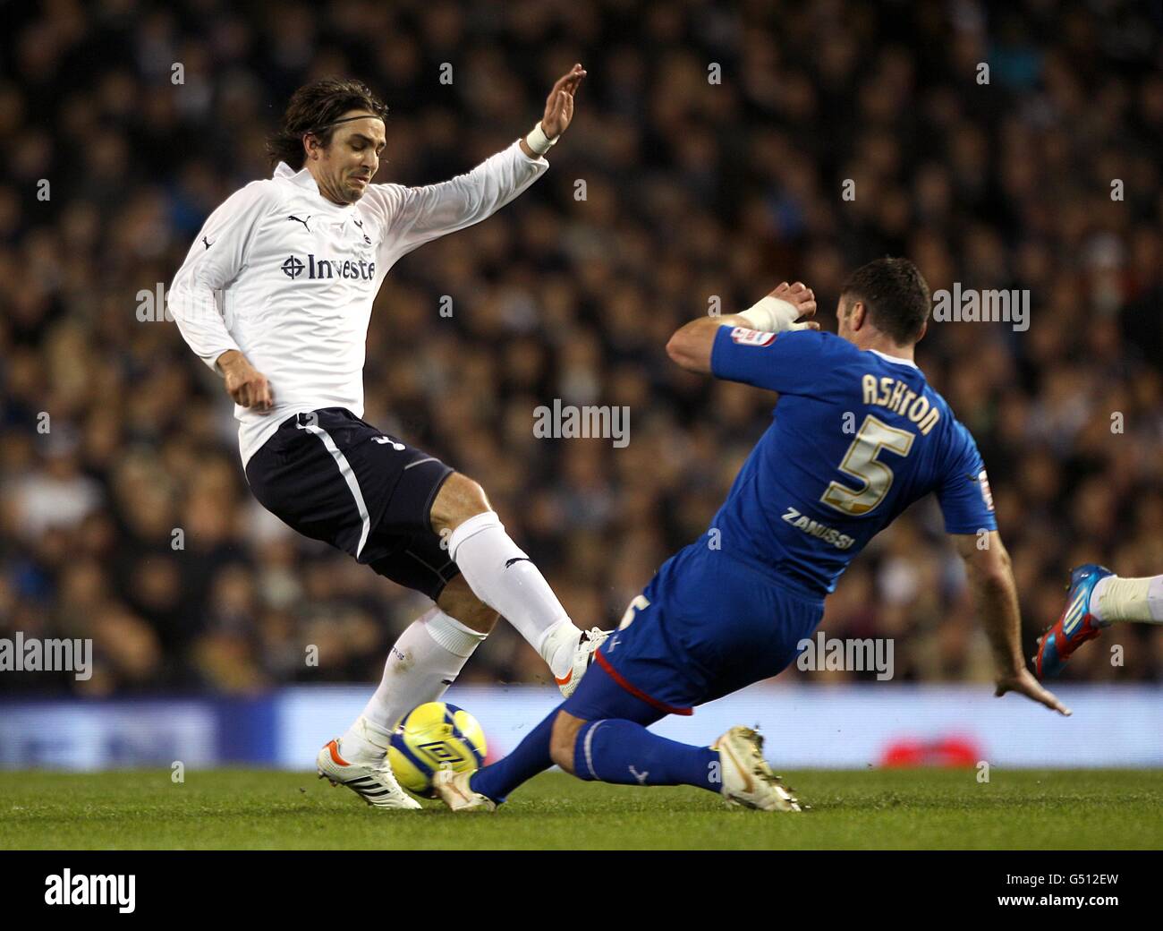 Stevenage's Jon Ashton (right) slides in to challenge Tottenham Hotspur ...