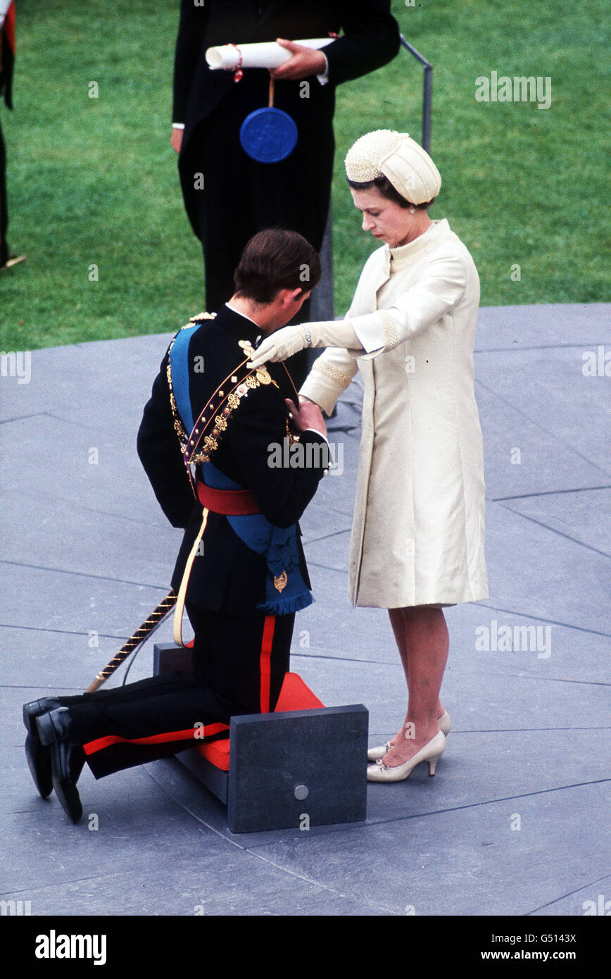The Queen puts sword and belt on Prince of Wales during the Investiture ...