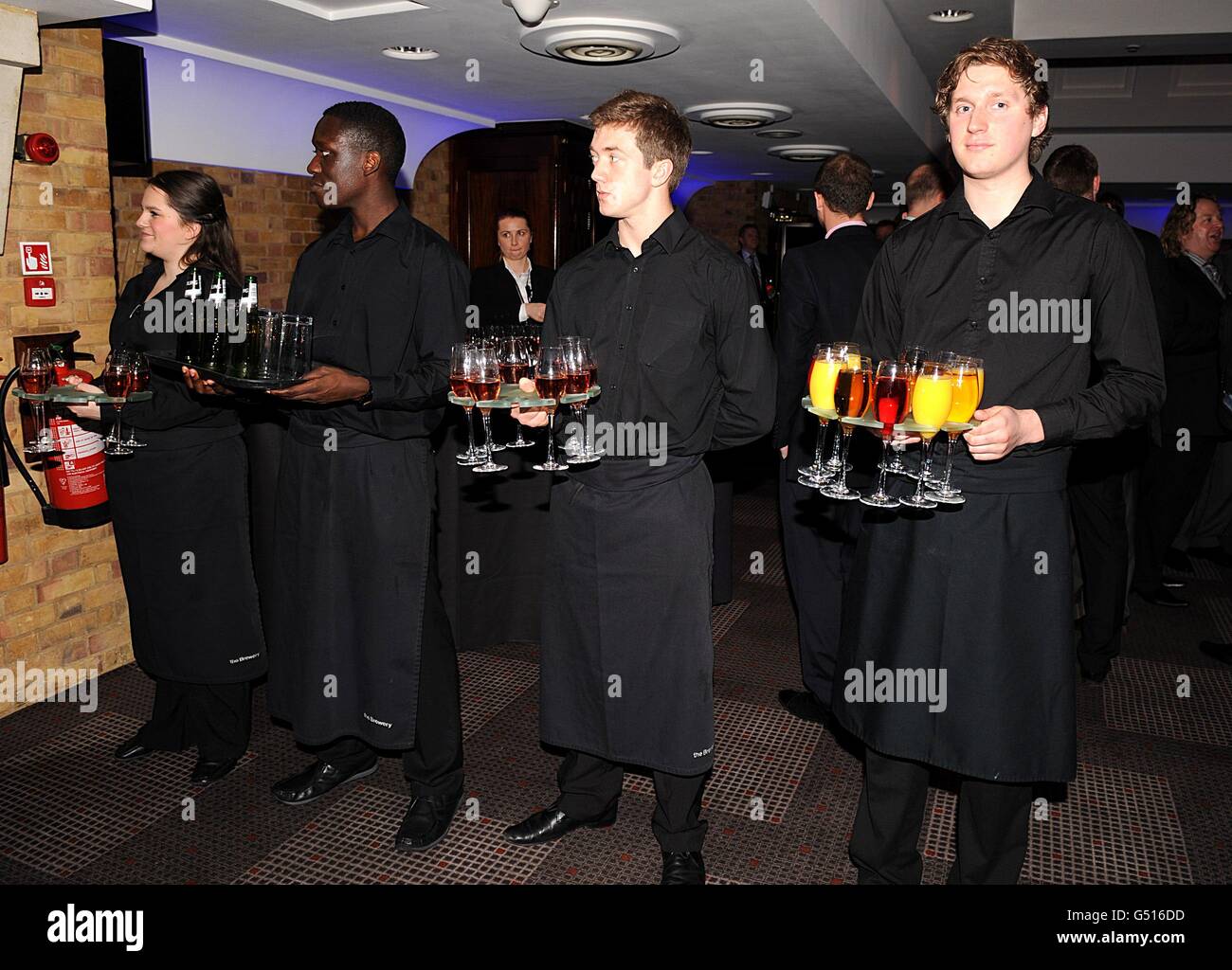 Waiters stand by with drinks during the drinks reception at the 2012 ...