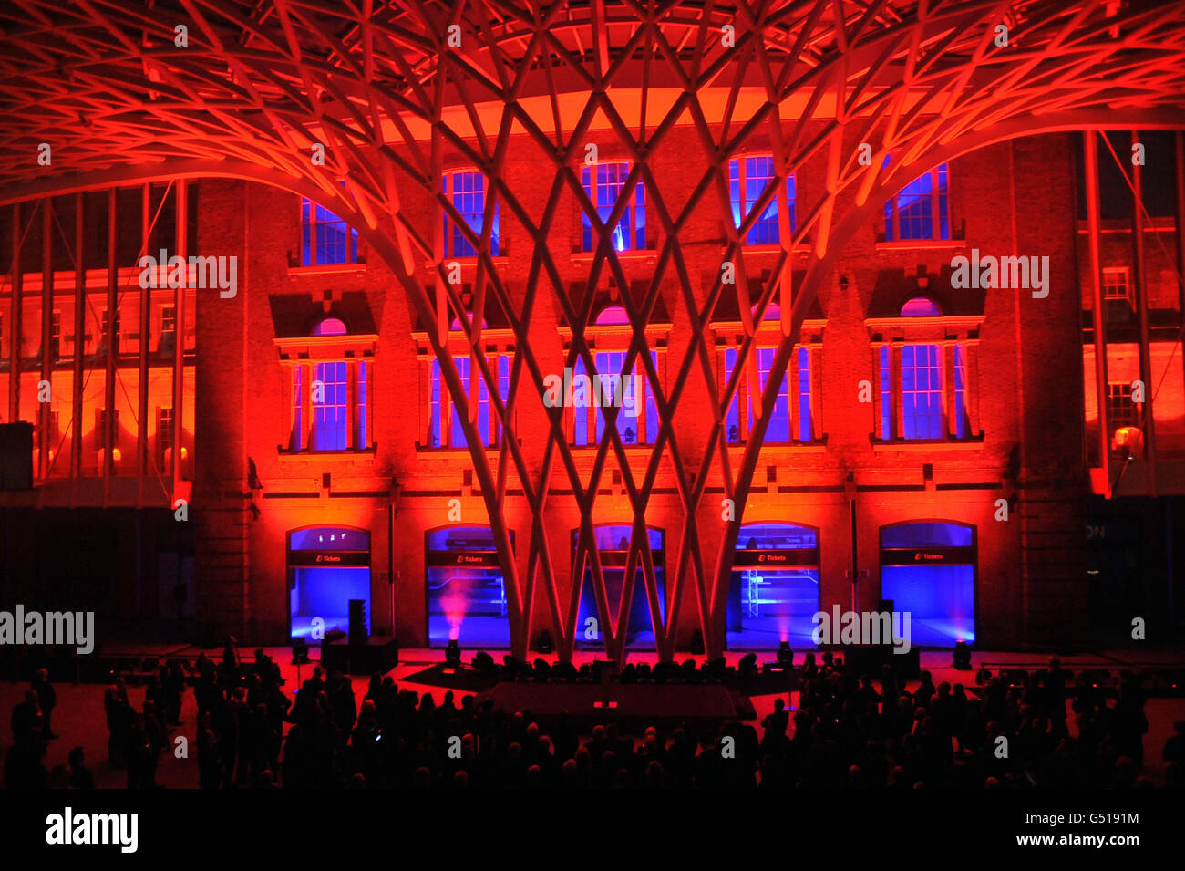 Visitors watch a light show at King's Cross station in London, where ...