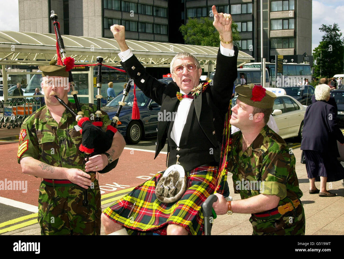 Scottish boxer Ken Buchanan is piped in by Sergeant Dave Smith (L) and ...
