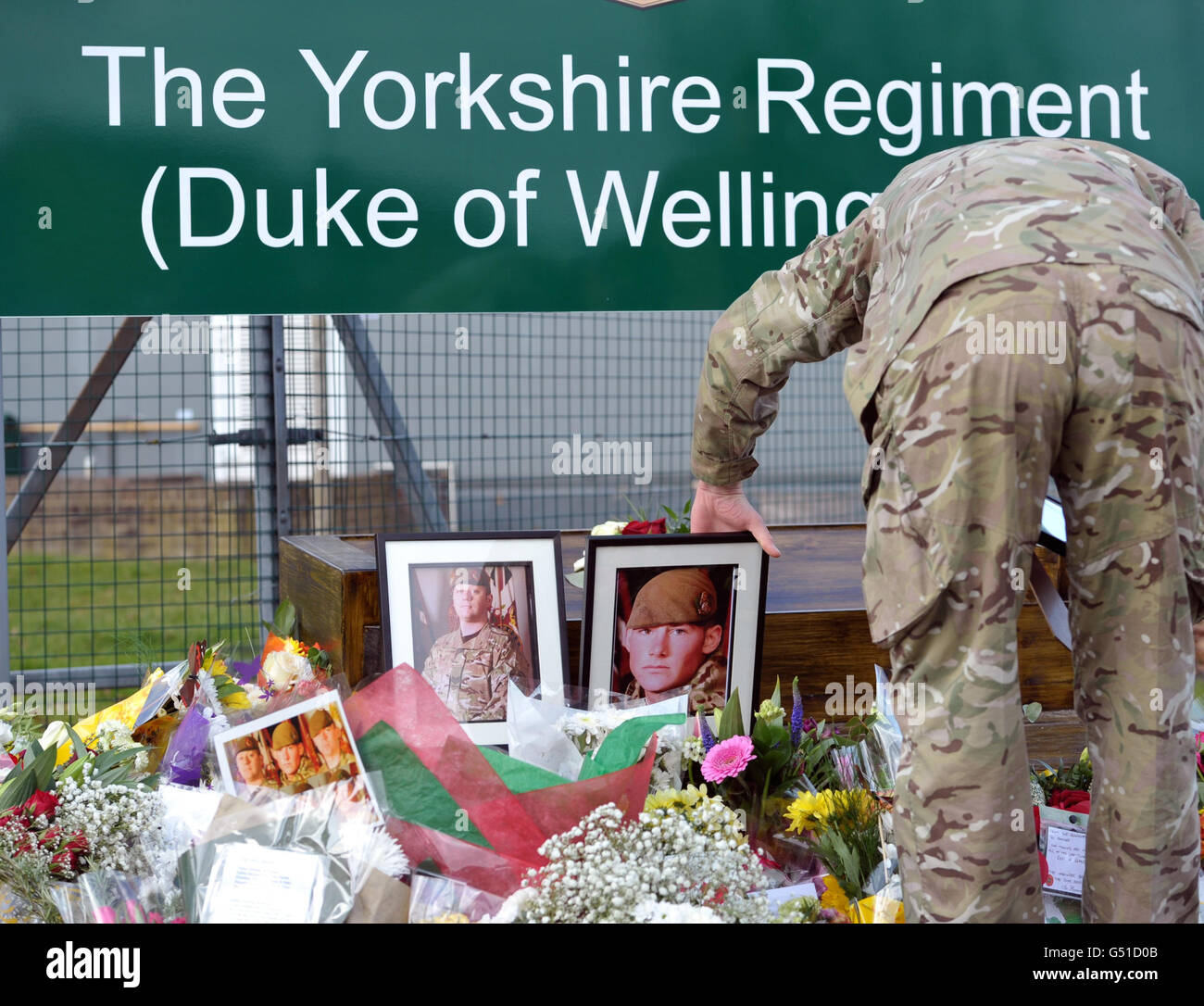 Soldiers place pictures among floral tributes at the 3rd Battalion The ...