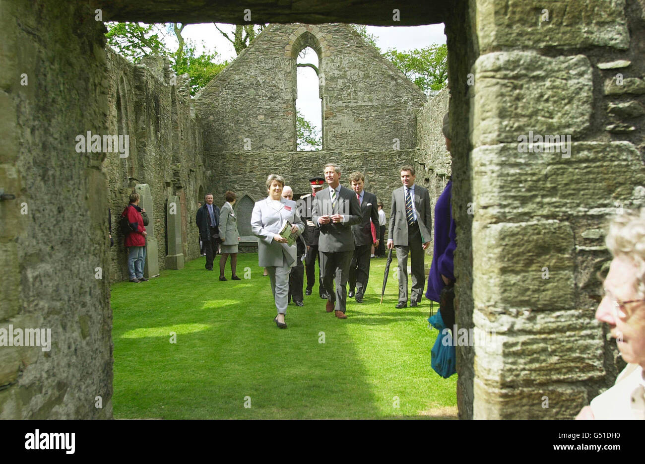 A wellwisher peers around the corner as HRH The Prince of Wales walks ...