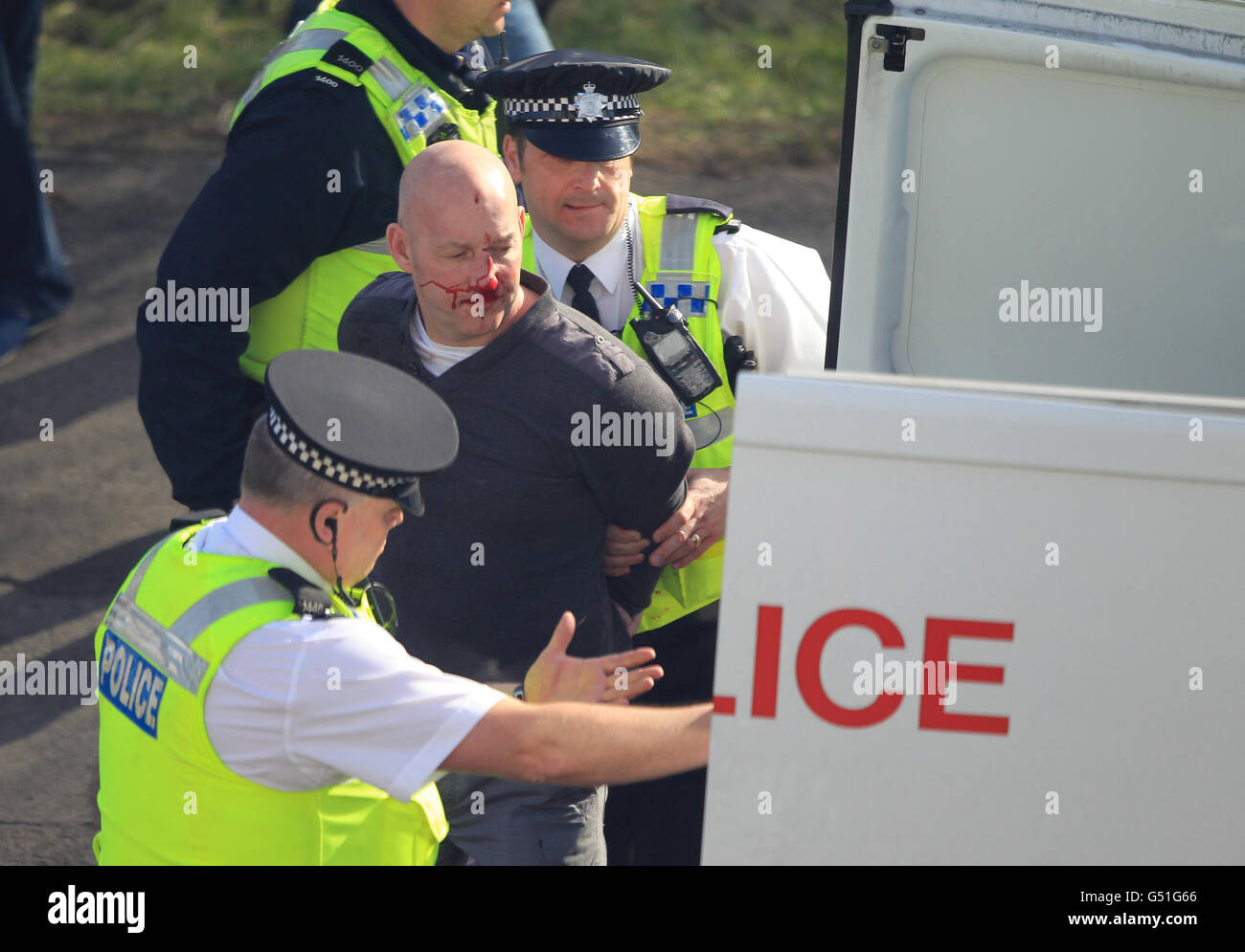 A man is arrested by the police and led into a police van after the ...