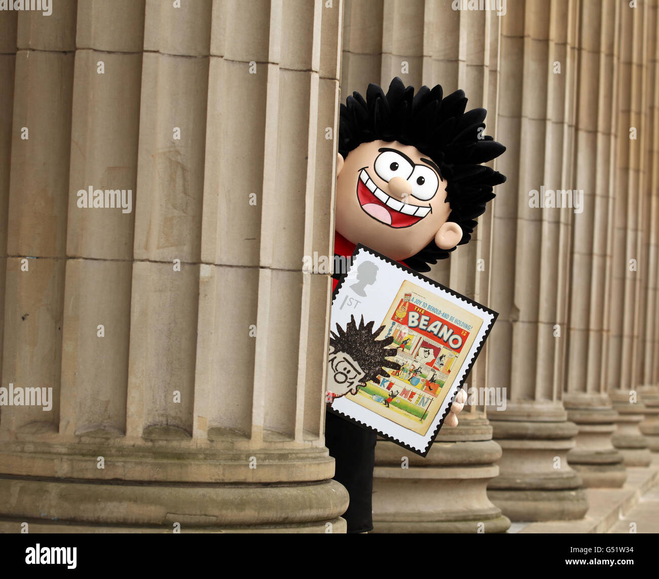 Dennis the Menace poses with an enlarged version of the new Beano stamp ...