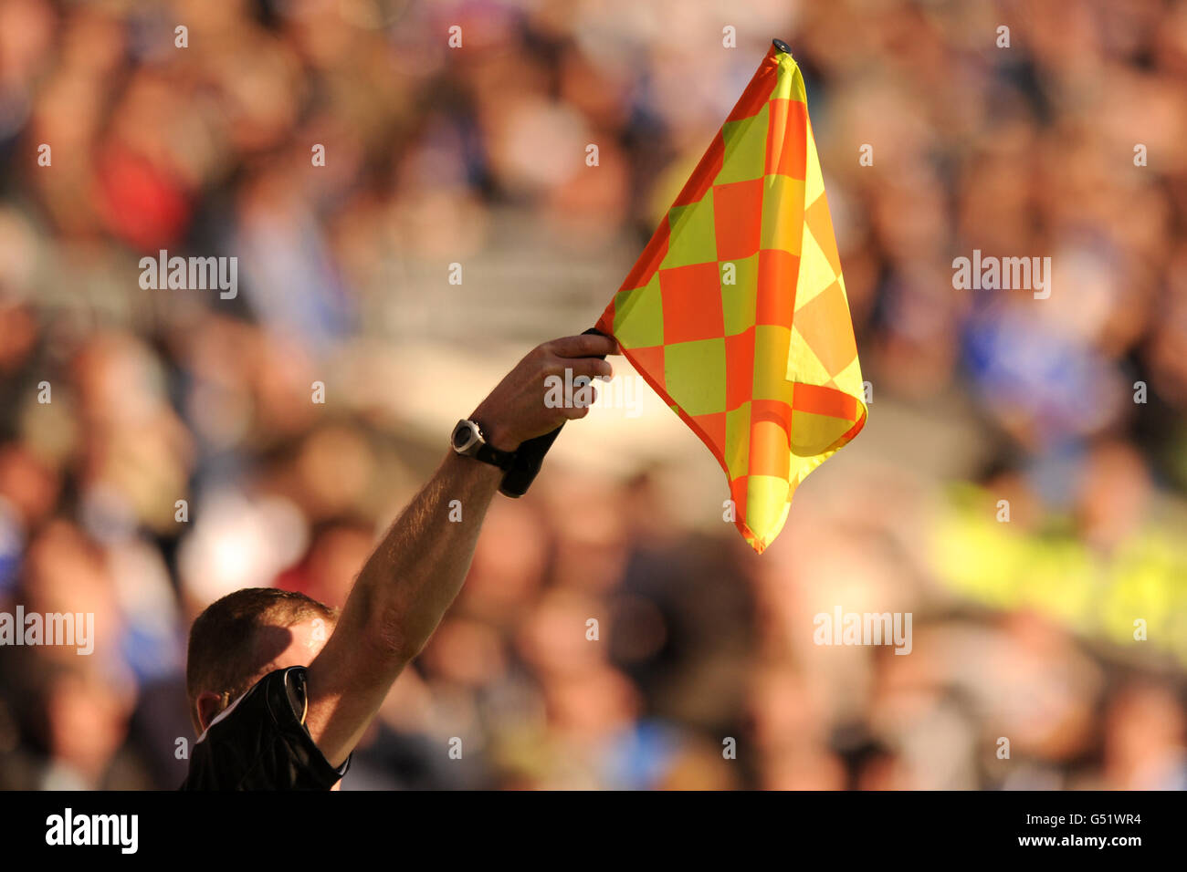 The assistant referee raises his flag on the touchline Stock Photo - Alamy
