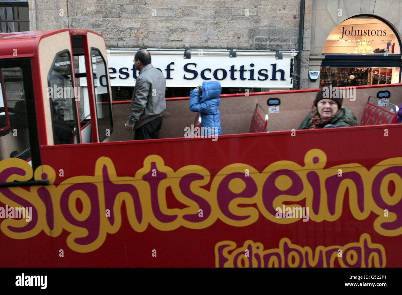 An Edinburgh sightseeing tour bus drives past outside the Scottish ...