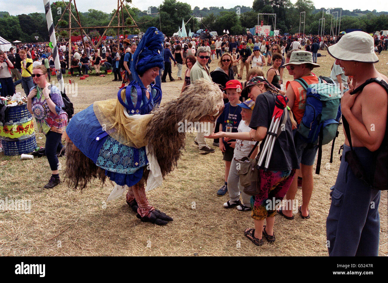 Glastonbury 2000 ostrich. Children play with a woman dressed as an ...