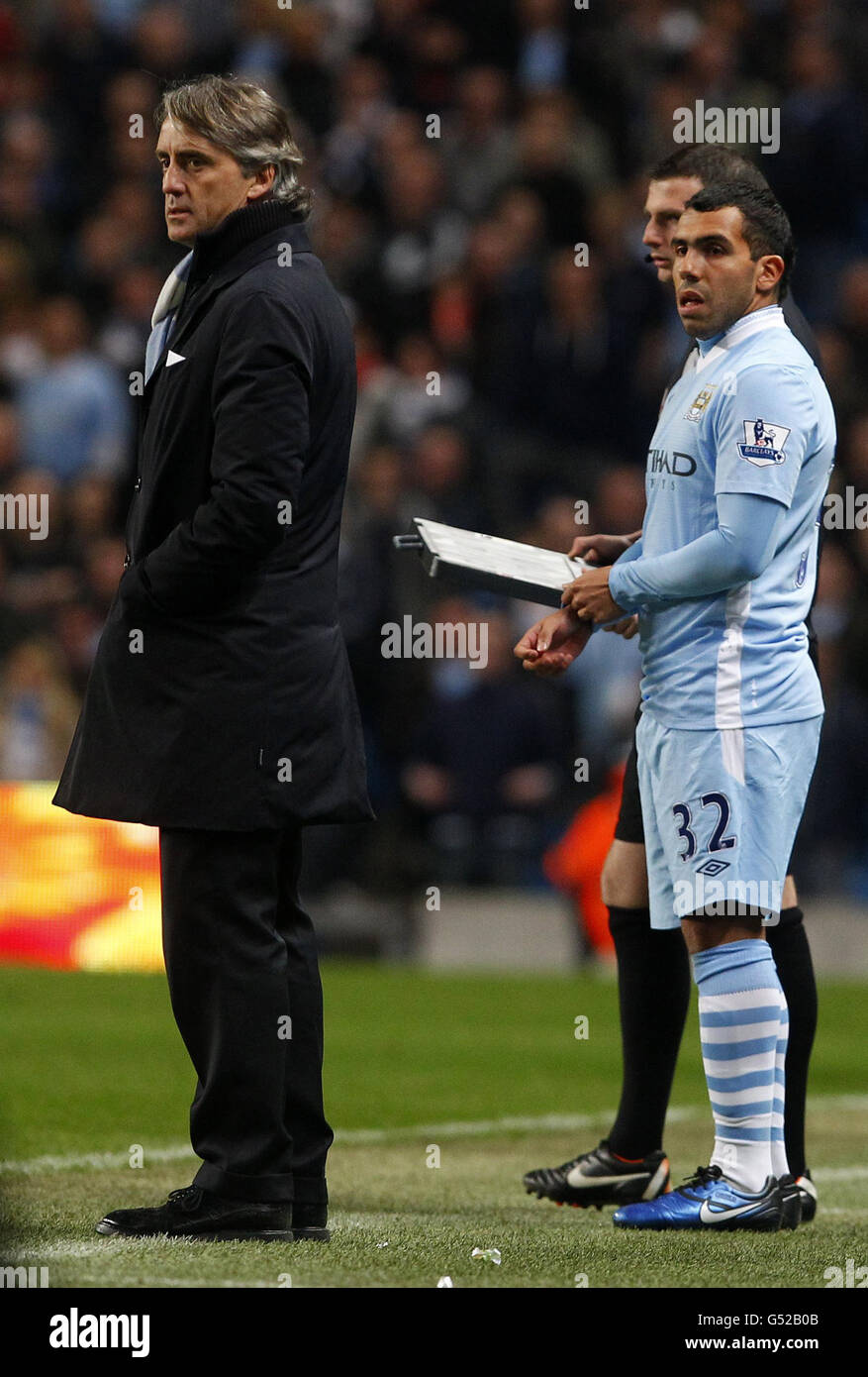 Manchester City manager Roberto Mancini watches the action as Carlos ...