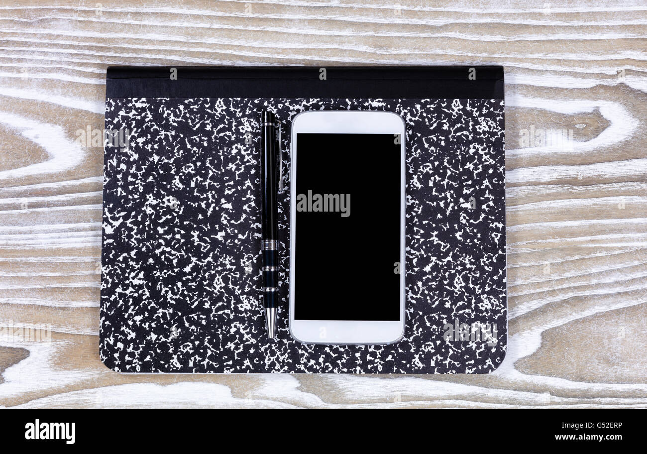 Notepad, pen and cell phone on top of faded white wooden desktop ...