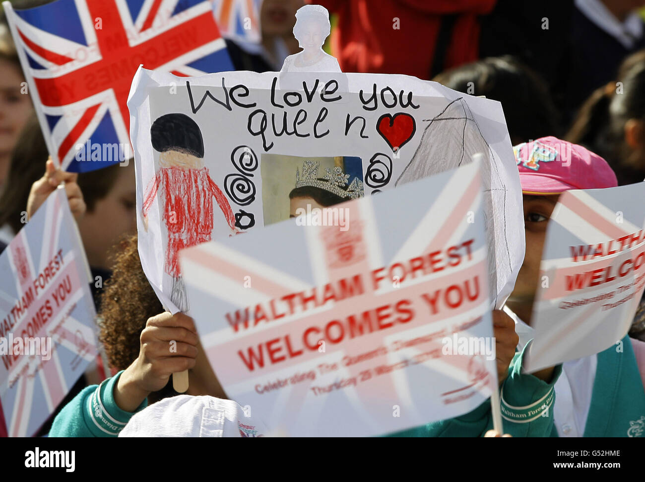 School children with home made signs await the arrival of Queen ...