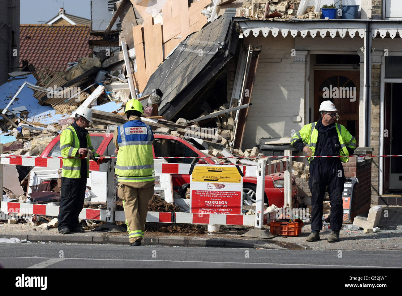 Fire and Rescue workers survey the scene at a house, divided into three ...