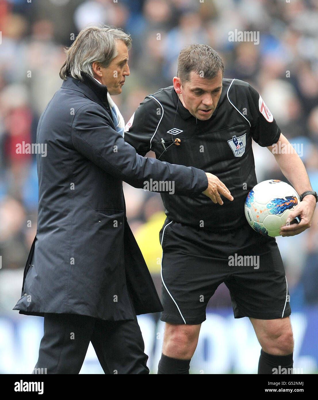 Manchester City manager Roberto Mancini talks with referee Phil Dowd ...