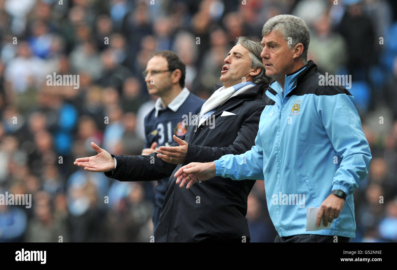 Manchester City manager Roberto Mancini and his assistant Brian Kidd ...