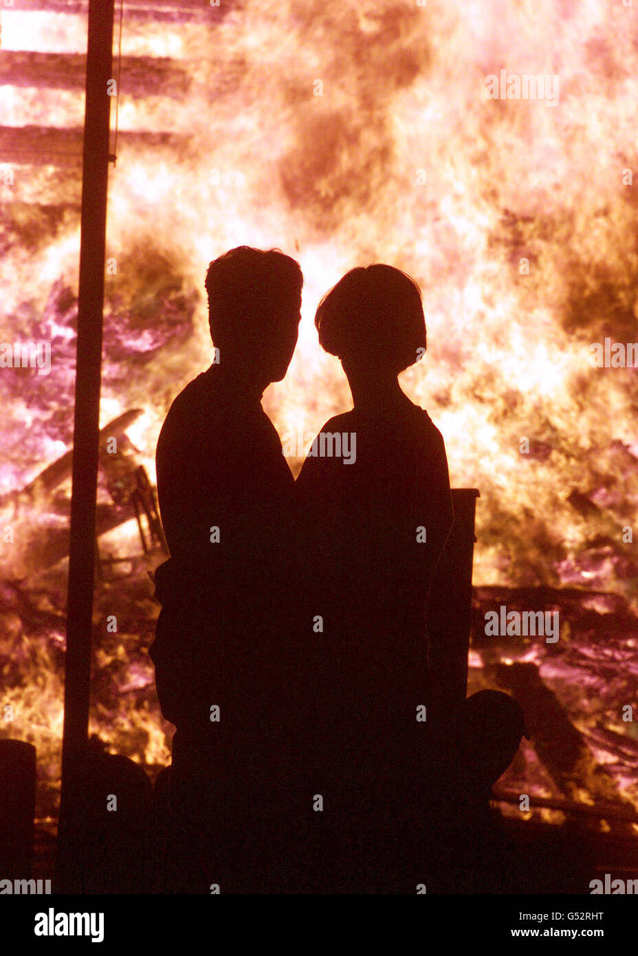 A couple watch the bonfire at Sandy Row in Belfast city centre ...