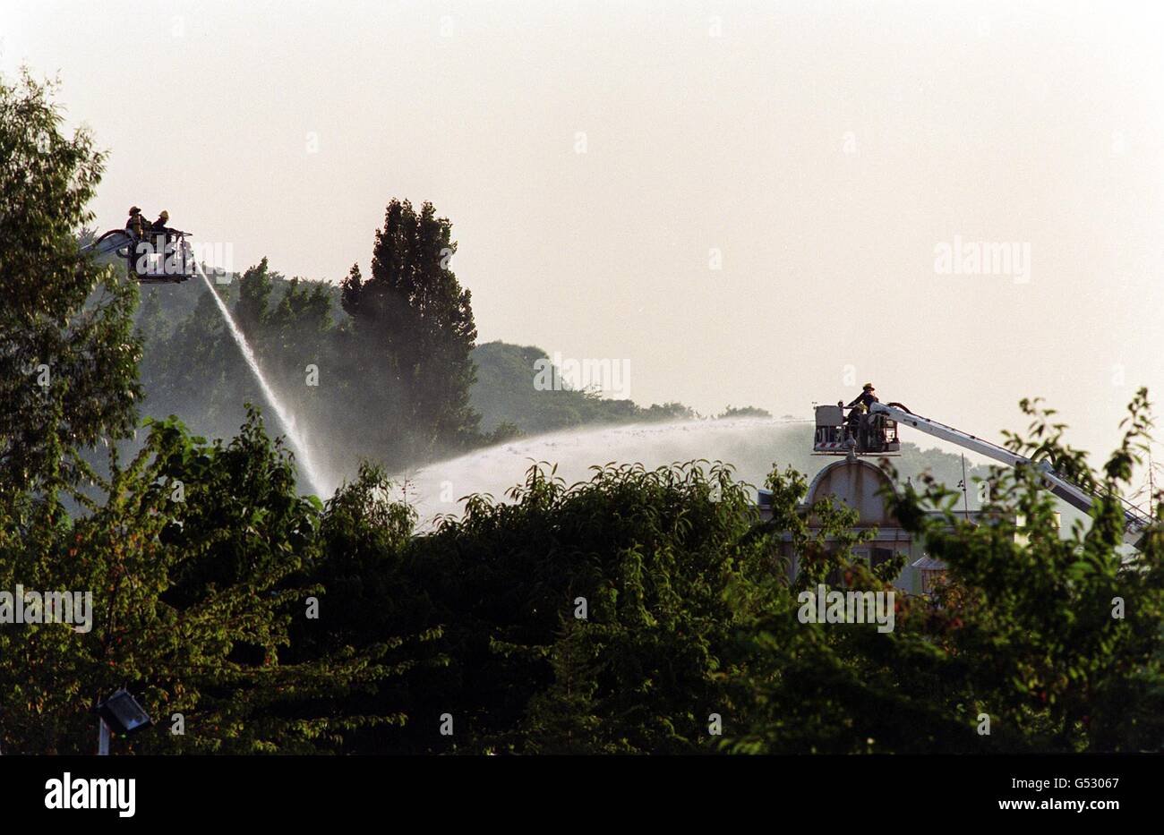 Fire fighters dampen down the fire at Thorpe Park in Surrey. More than ...