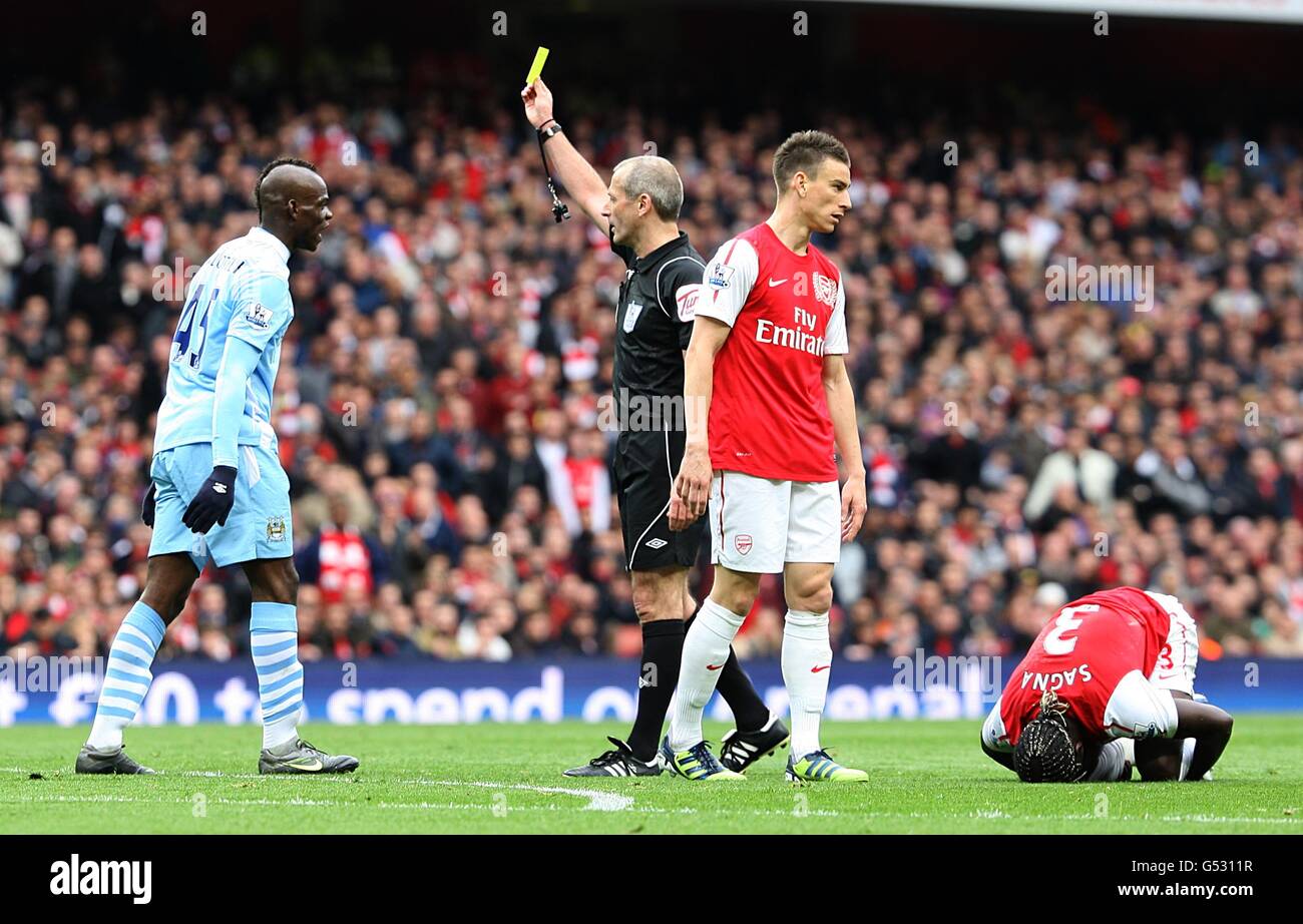 Referee Martin Atkinson (centre) shows Manchester City's Mario ...