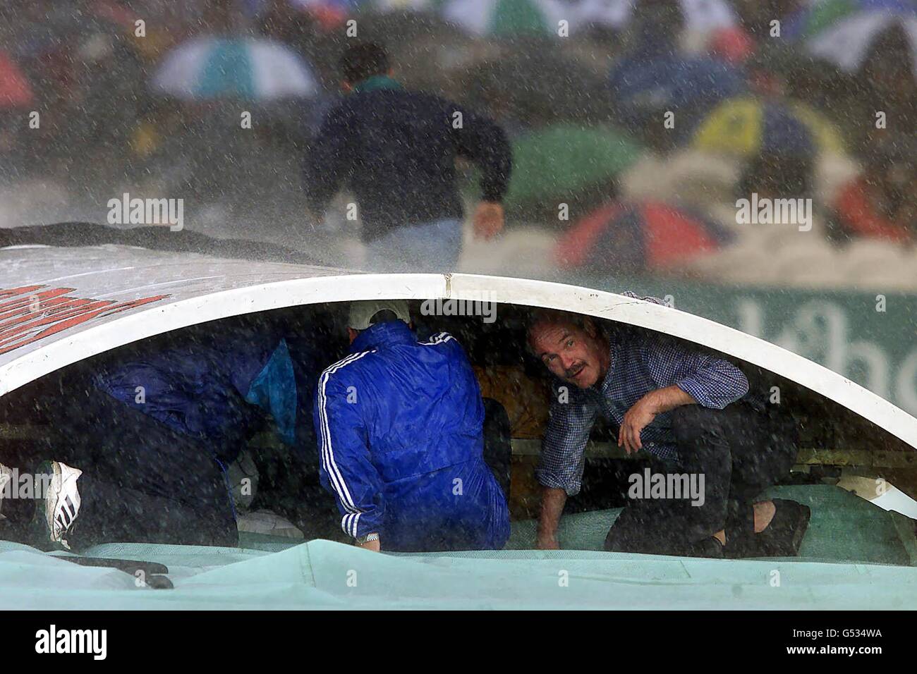 Lancashire head groundsman peter marren shelters under the covers hi ...