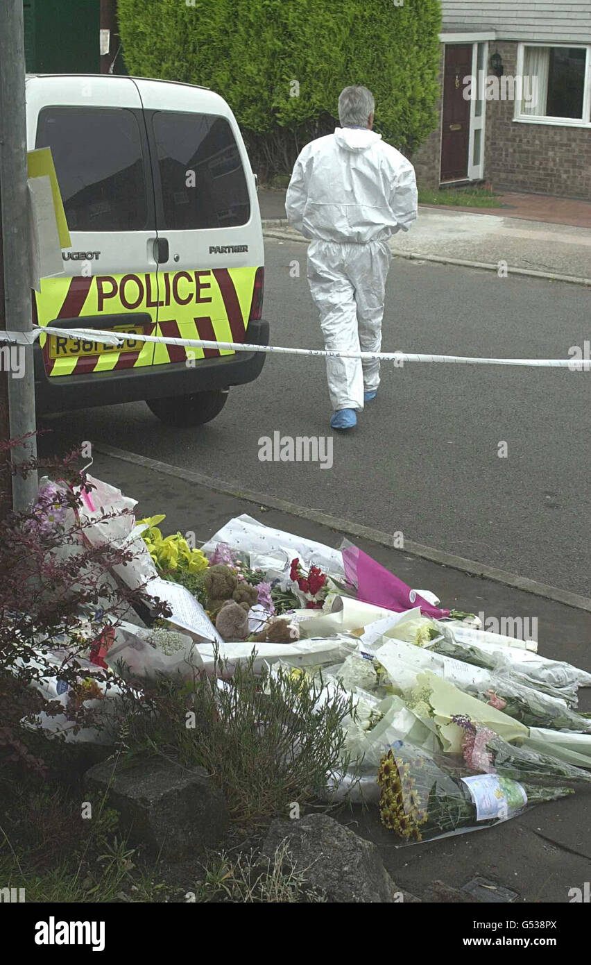 Floral tributes line the pavement as forensic experts continue their ...