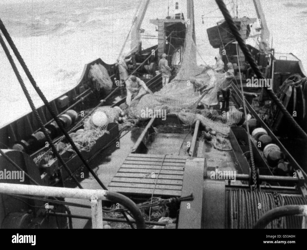 Crew members on board the 'Flydea' fishing trawler prepare to lower the ...