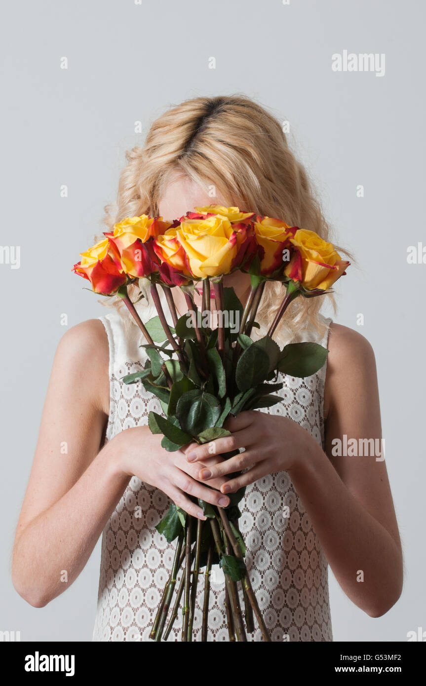 Woman hiding face with roses Stock Photo - Alamy