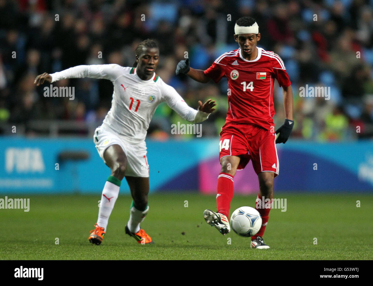 Oman's Mohamed Al Maashari is challenged by Senegal's Ibrahima Balde ...