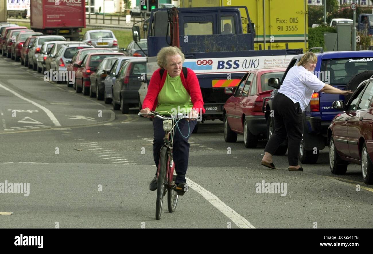 A cyclist passes a queue of cars at a Nottingham petrol station. The ...