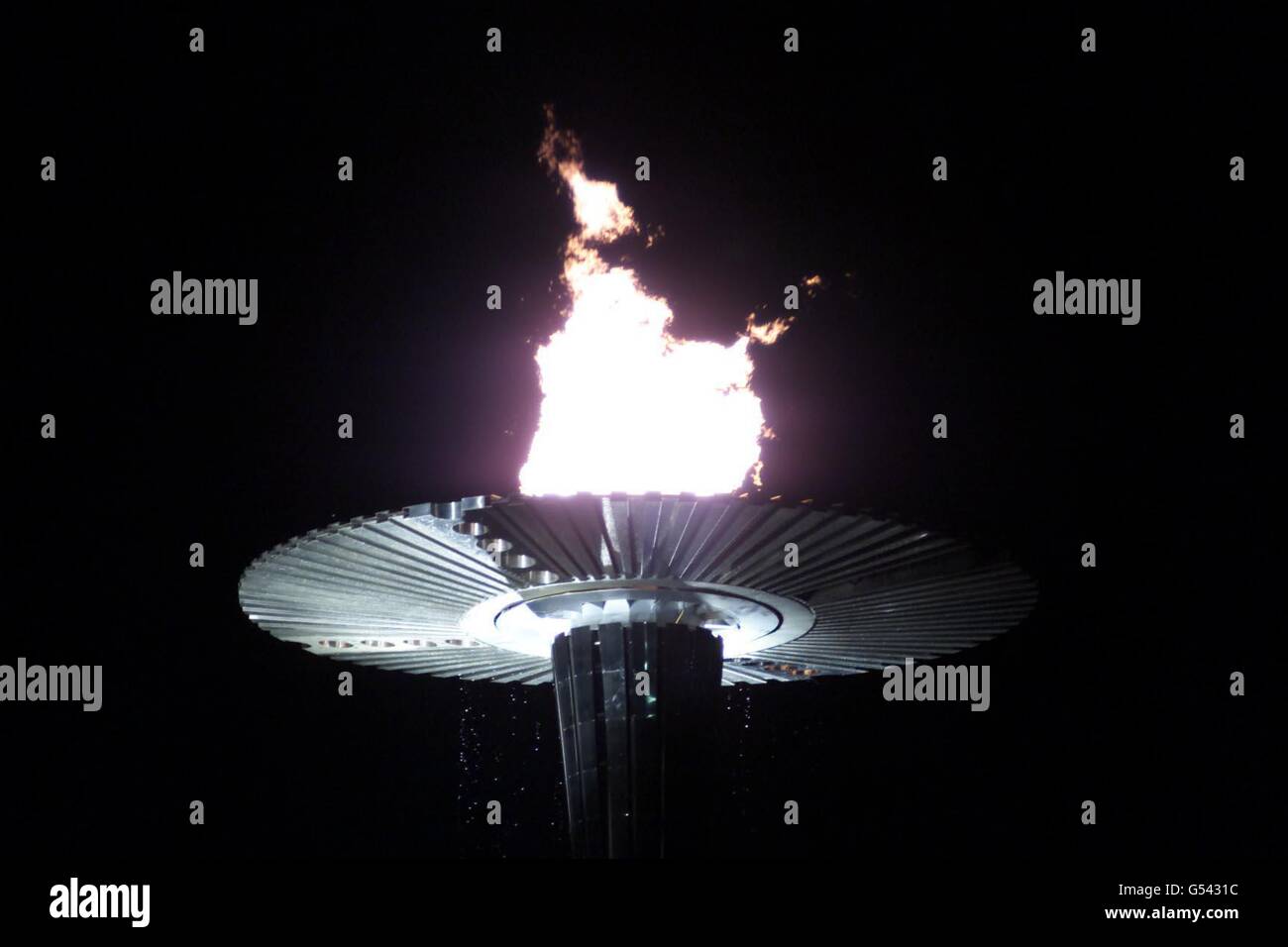 The Olympic Flame lights up the night sky after the 2000 Olympic Games ...