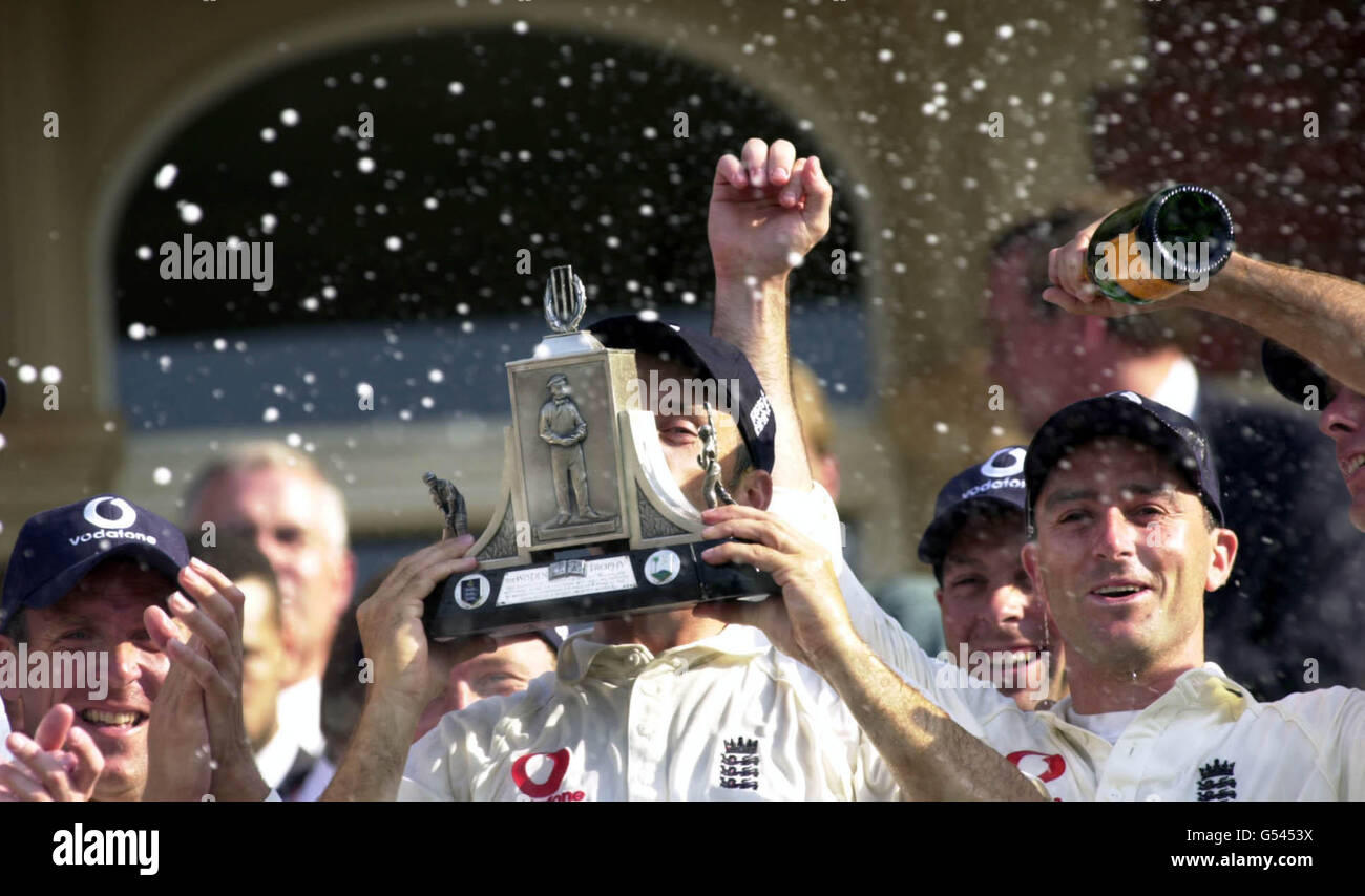 Sport cricket celebrating arms raised kissing trophy spraying champagne ...