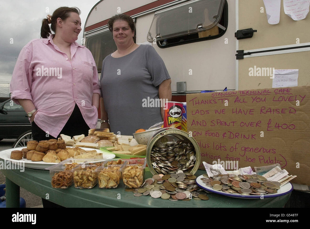 Carole Ball and Alison Tate in front of a table of sandwiches and pies ...