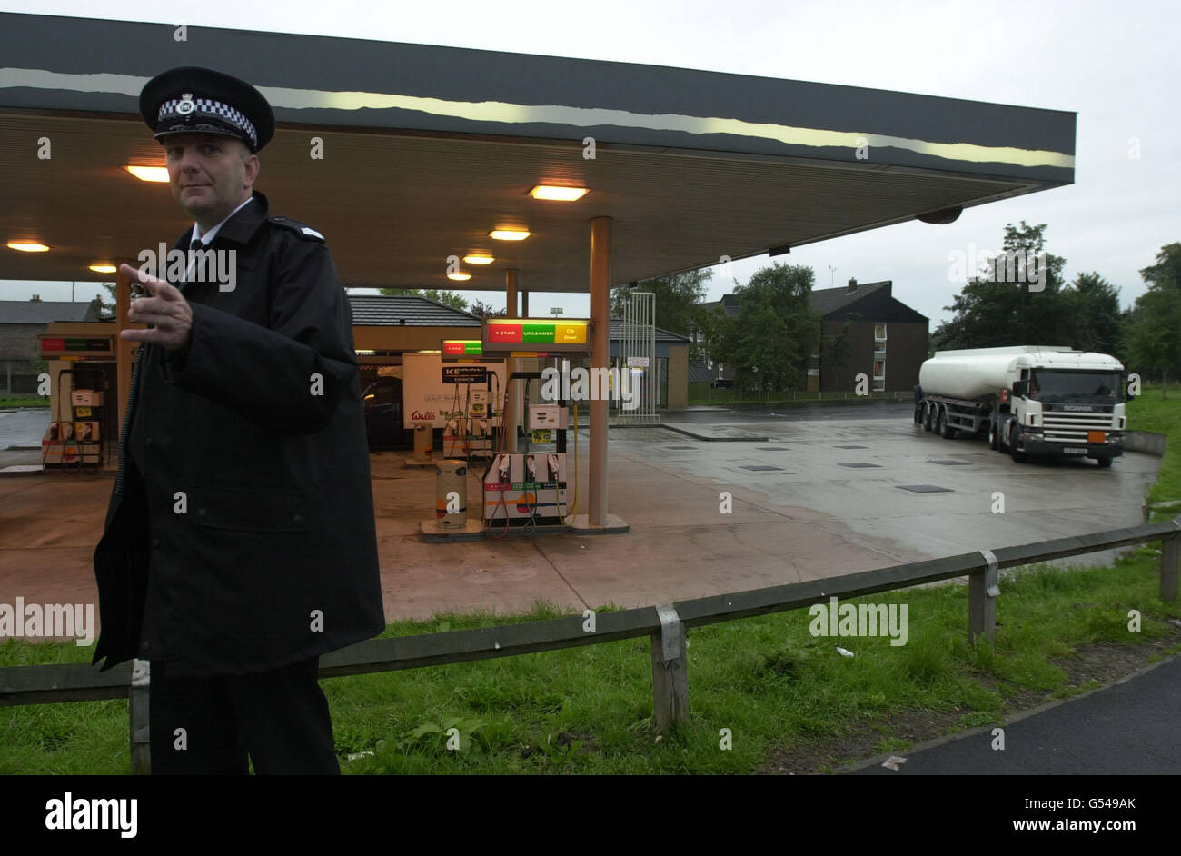A police officer stands by as a tanker delivers fuel to a garage in ...