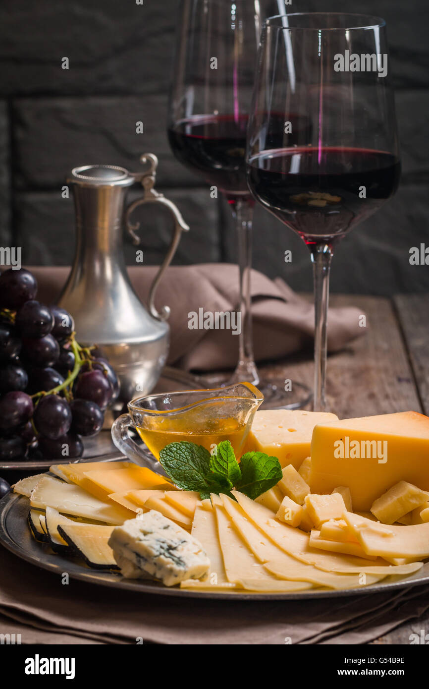 Refined still life of red wine, grapes and cheese Stock Photo - Alamy