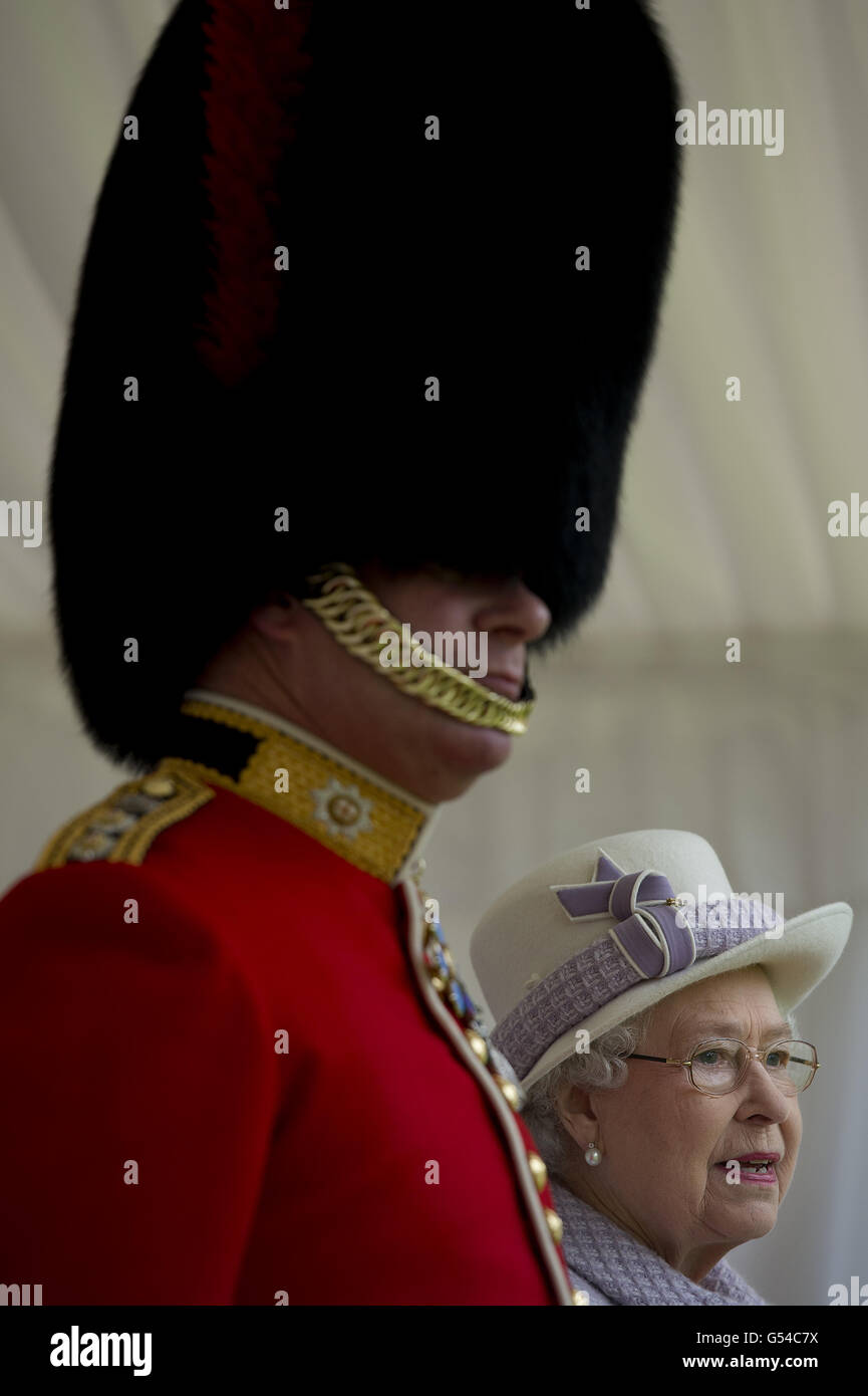Queen Elizabeth II stands with an officer as she watches a ceremony in ...