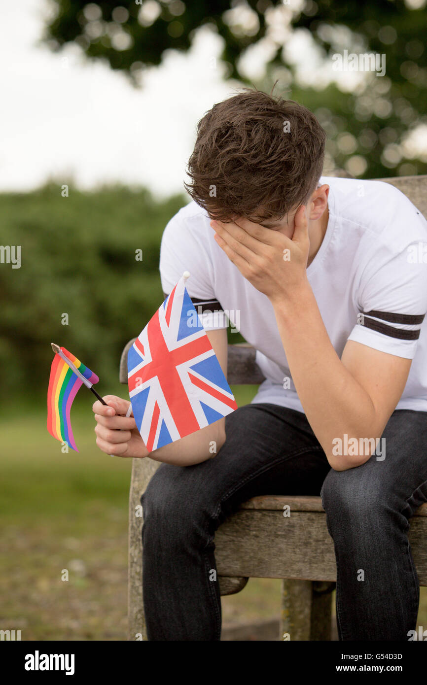 Depressed teenage boy with United Kingdom, Union Jack Flag and a Pride ...